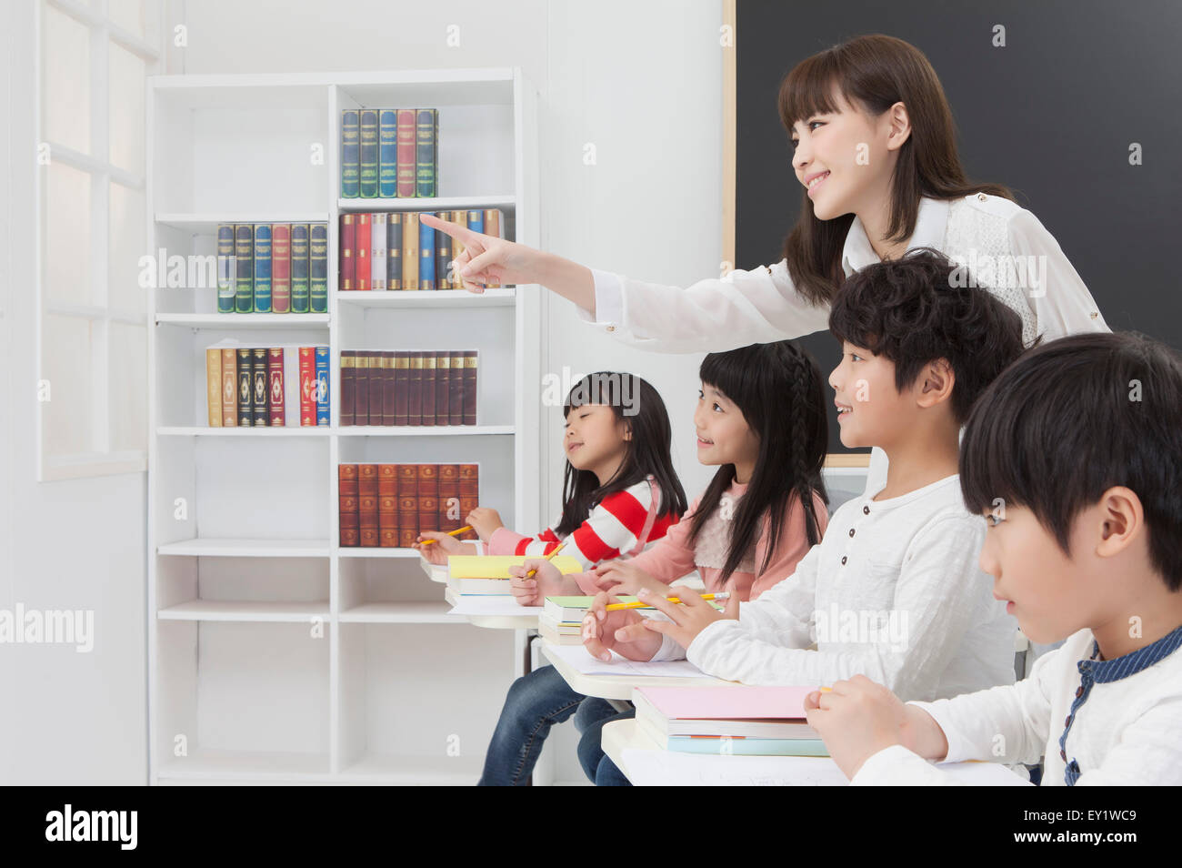 Young teacher teaching students in the classroom and smiling Stock ...