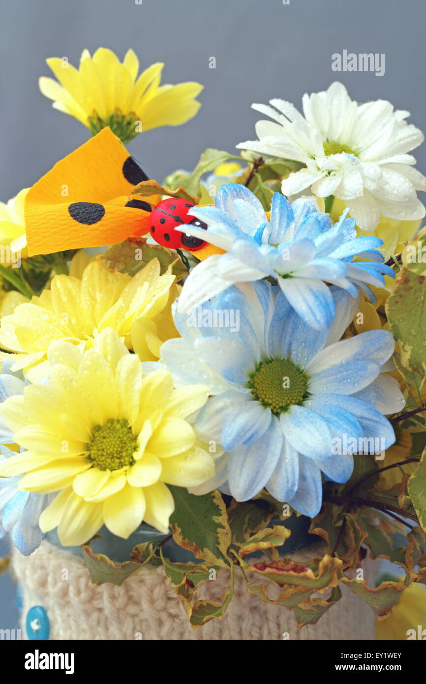 cute floral arrangement with yellow and blue daisies over gray ...