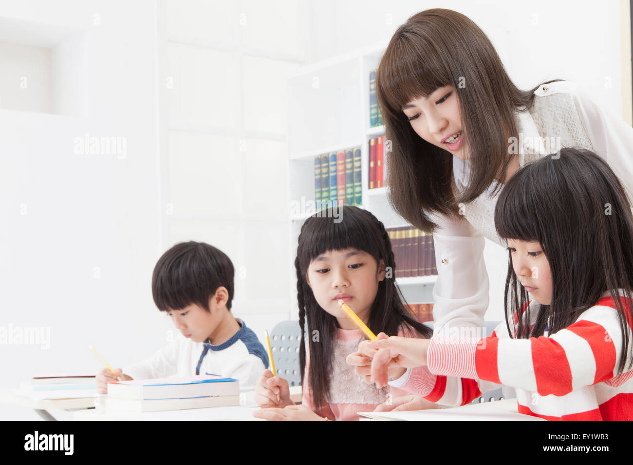 Young teacher teaching students in the classroom and smiling Stock ...
