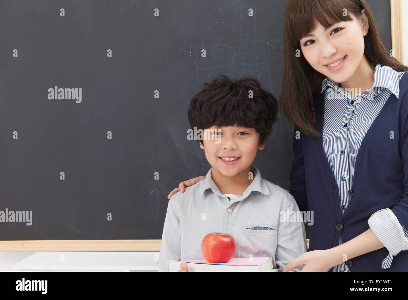 Young teacher and schoolboy standing in the classroom and smiling Stock ...