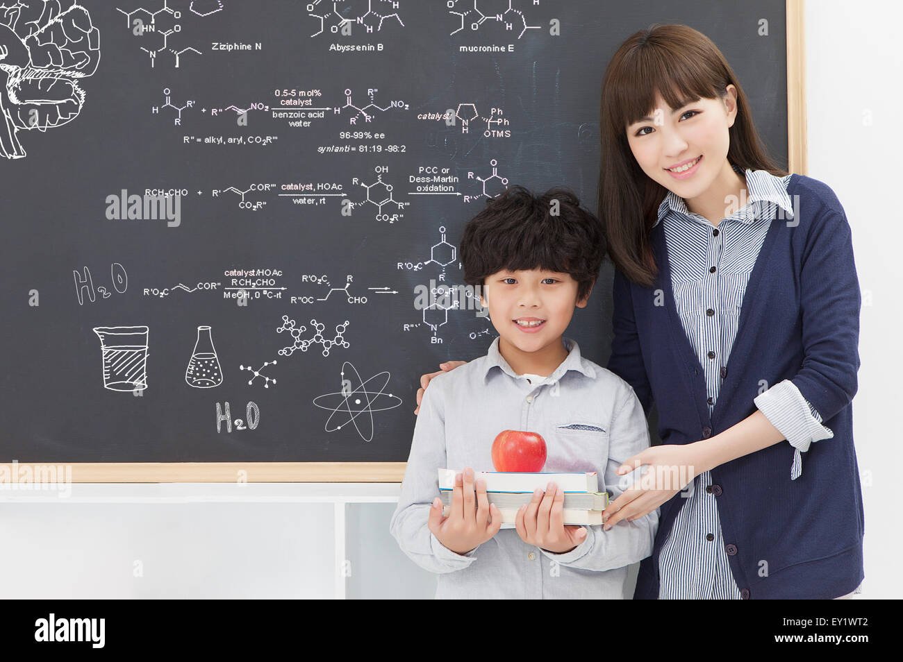 Young teacher and schoolboy standing in the classroom and smiling Stock ...