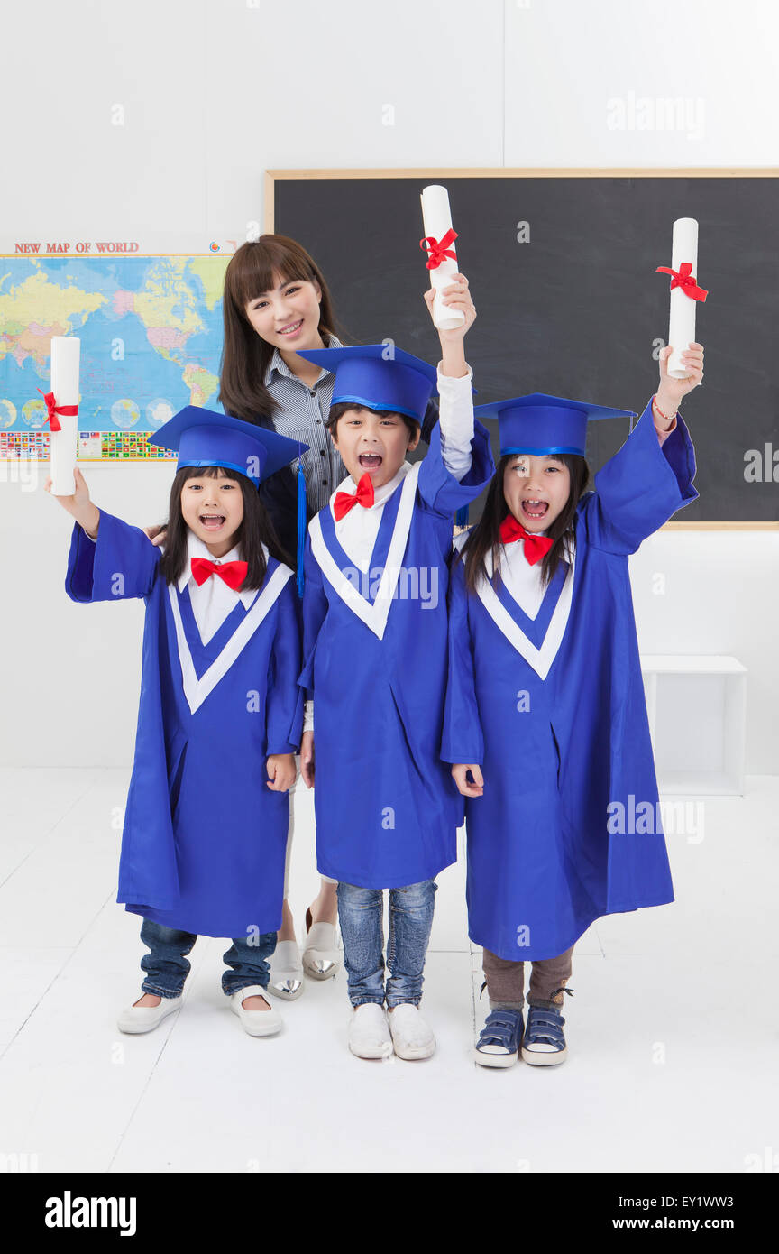 Young teacher and students with graduation gowns holding diploma with ...