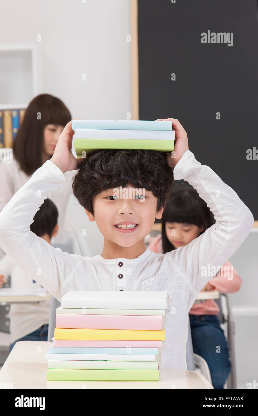 Children holding a stack of books and smiling at the camera Stock Photo ...