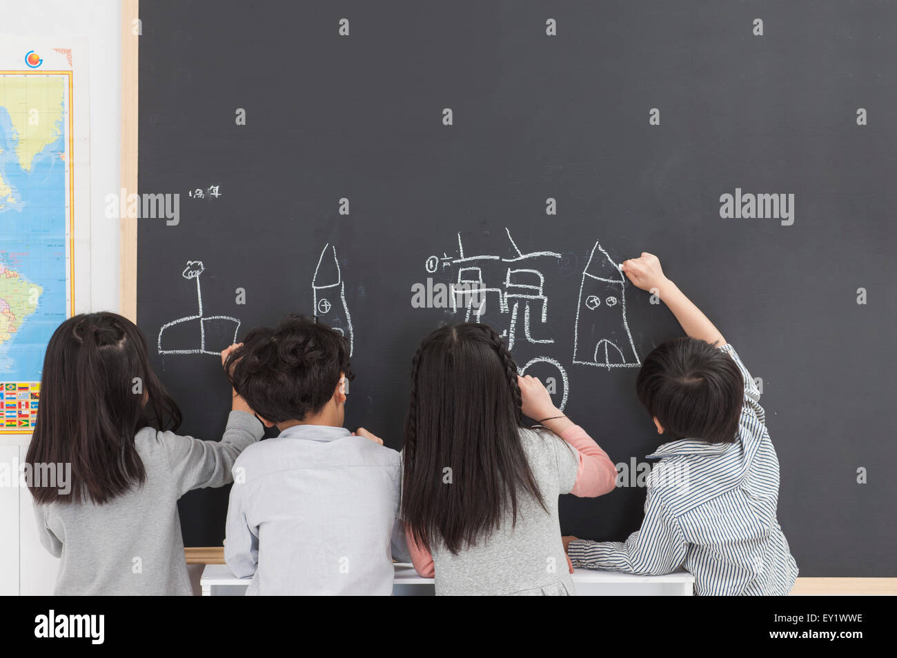 Children writing on the blackboard in the classroom Stock Photo - Alamy