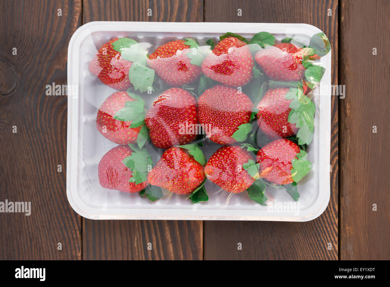 strawberries pack with film covered on wood Stock Photo - Alamy