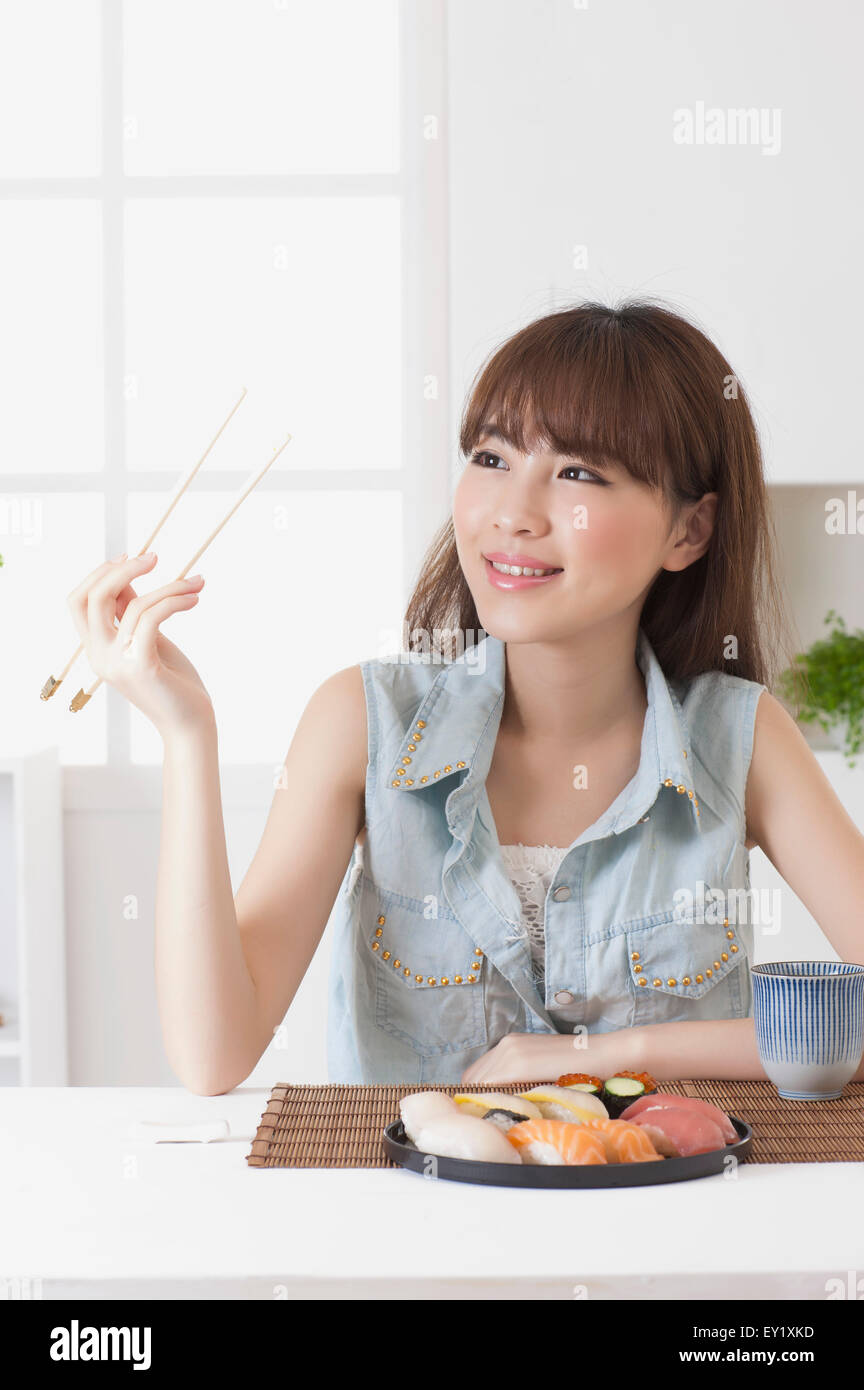 Young woman holding chopsticks and looking away with smile Stock Photo ...