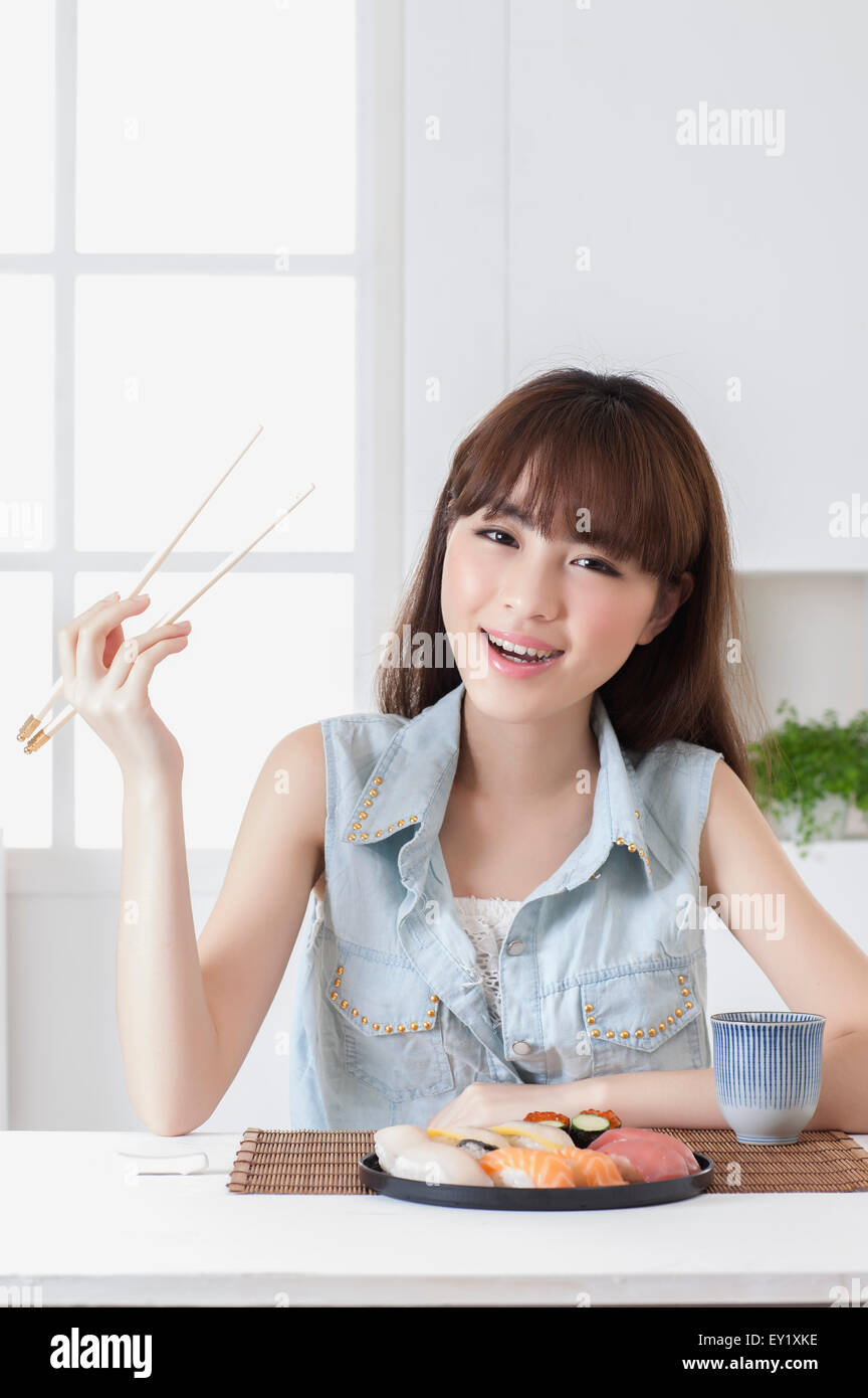 Young woman holding chopsticks and smiling at the camera Stock Photo ...