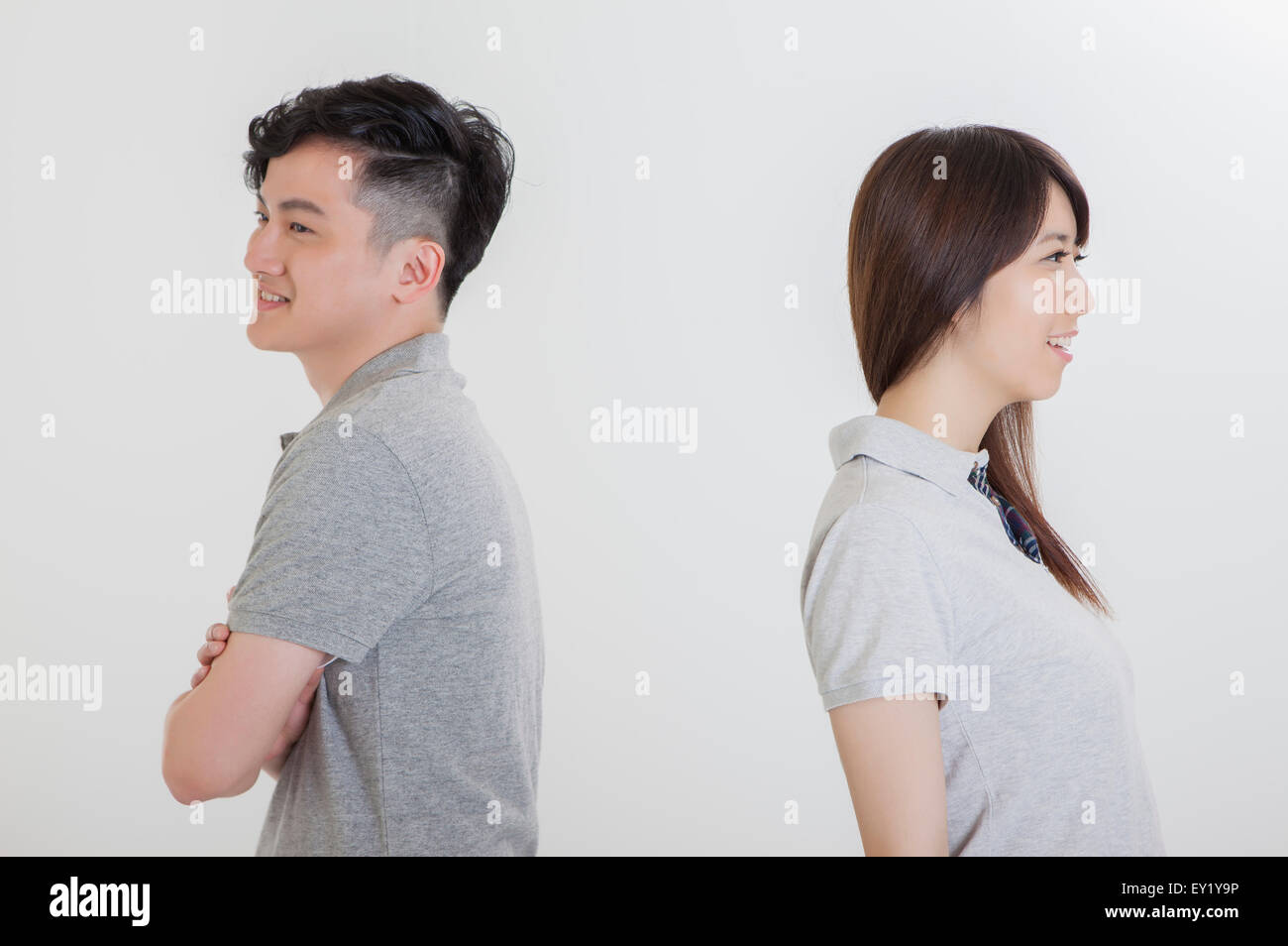 Young couple standing with back to back Stock Photo - Alamy