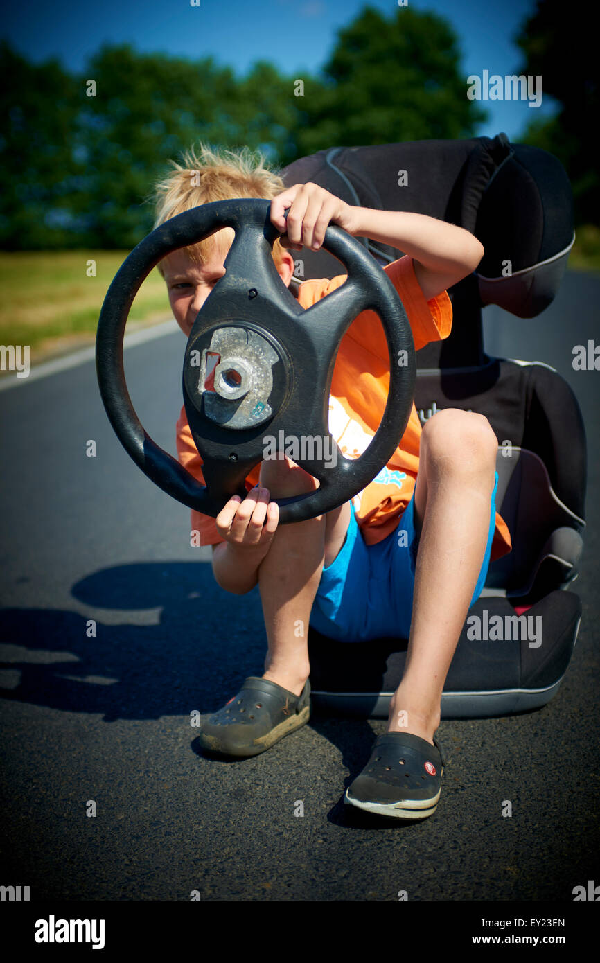Driver. Imaginary race. Child boy driving imaginary car on road holding ...
