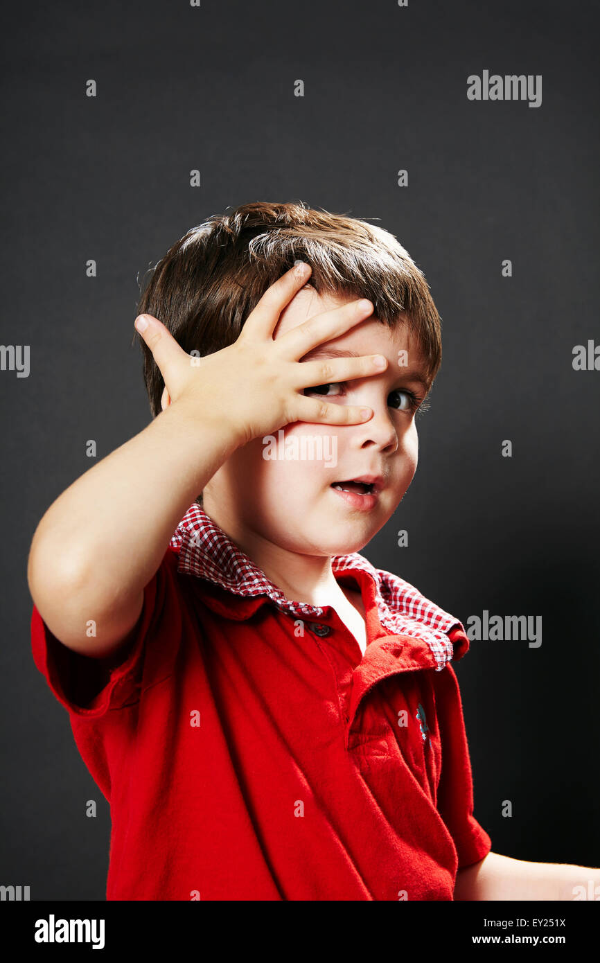 Portrait of young boy with hand on face Stock Photo - Alamy