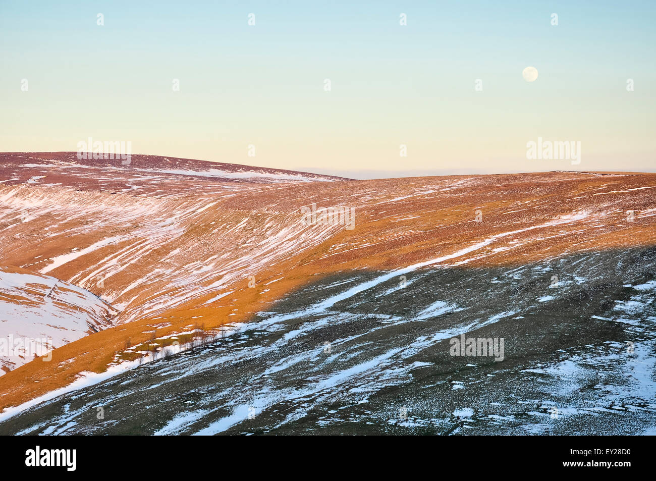 Moon rising above moorland with traces of late winter snow. Beautiful ...