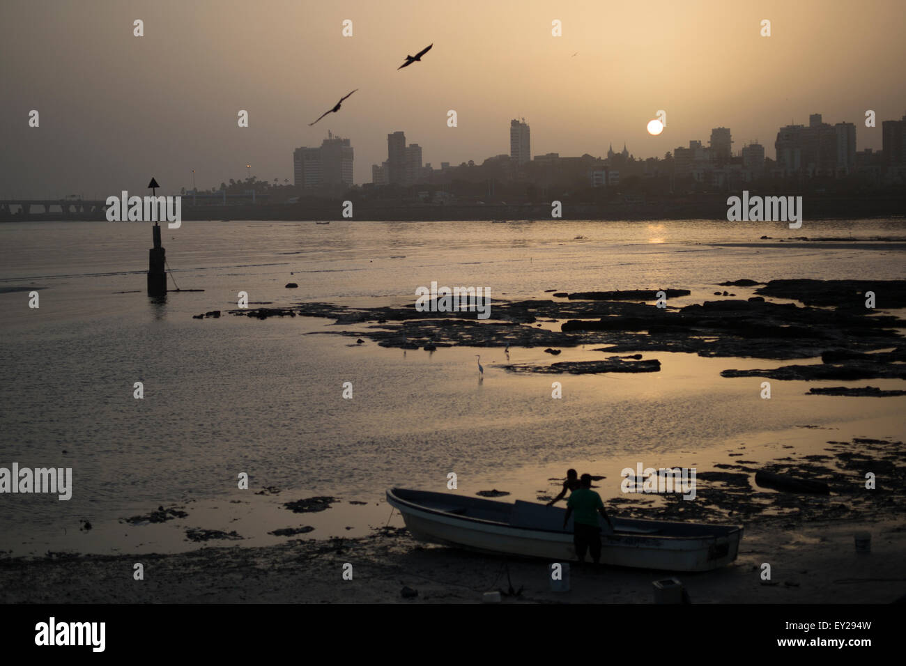Indian Koli Fishermen checking their boats on the beach at sunset in ...