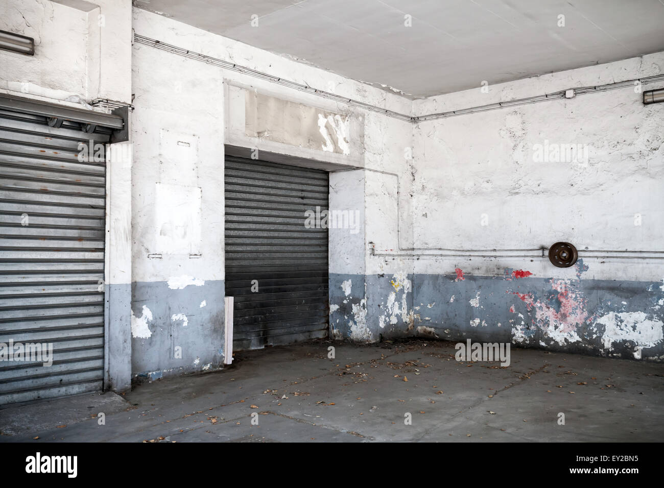 Abstract empty white interior of old automotive garage with asphalt ...