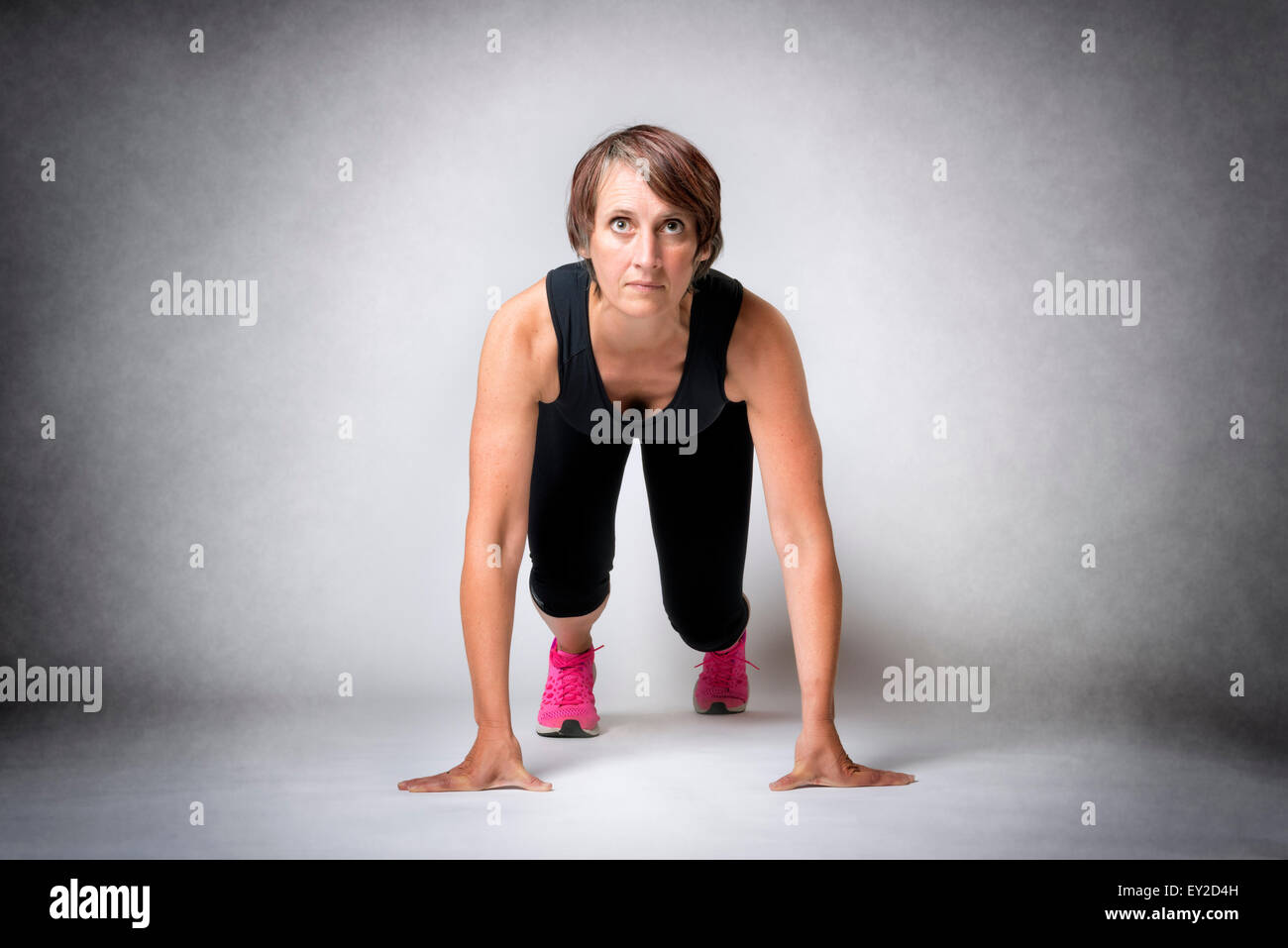 Image of running middle aged handsome woman in running start position ...