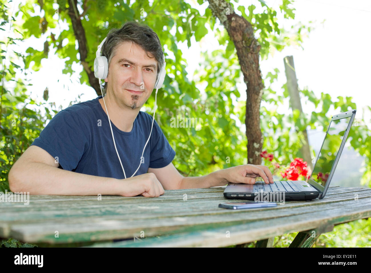 man sitting outdoor working with a laptop Stock Photo - Alamy