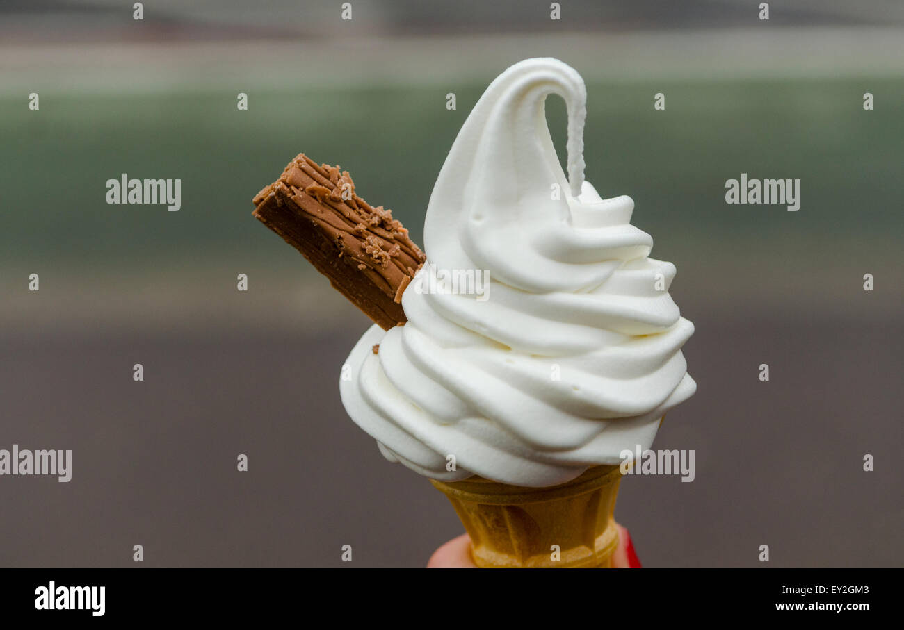 Woman Holding an Ice Cream Cornet with Flake Stock Photo - Alamy