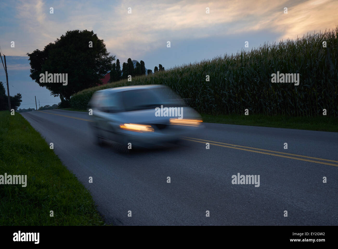 Car speeding down a farm road at twilight, Lancaster County ...