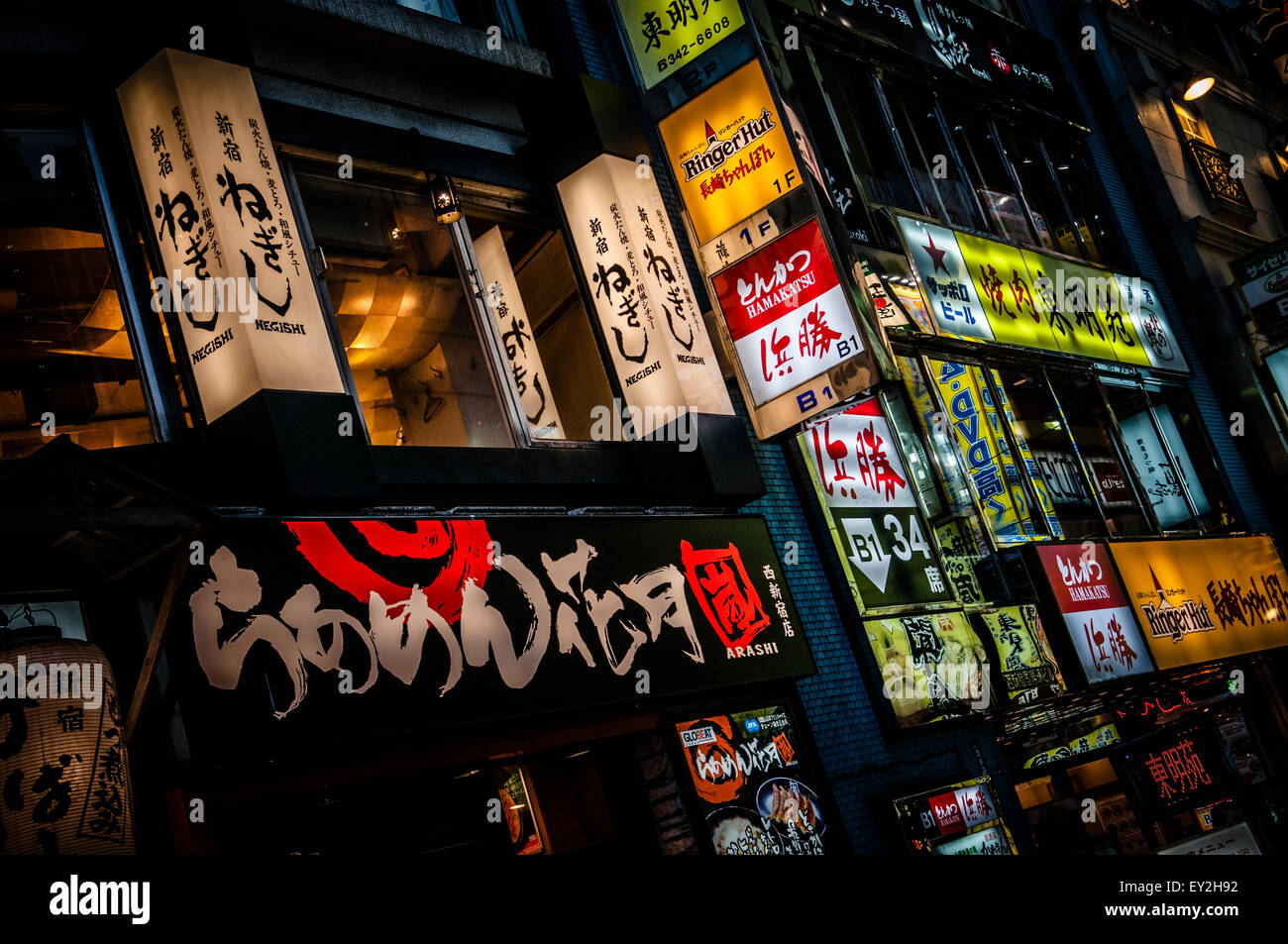 Neon lights advertising businesses as night falls in the Shibuya area ...
