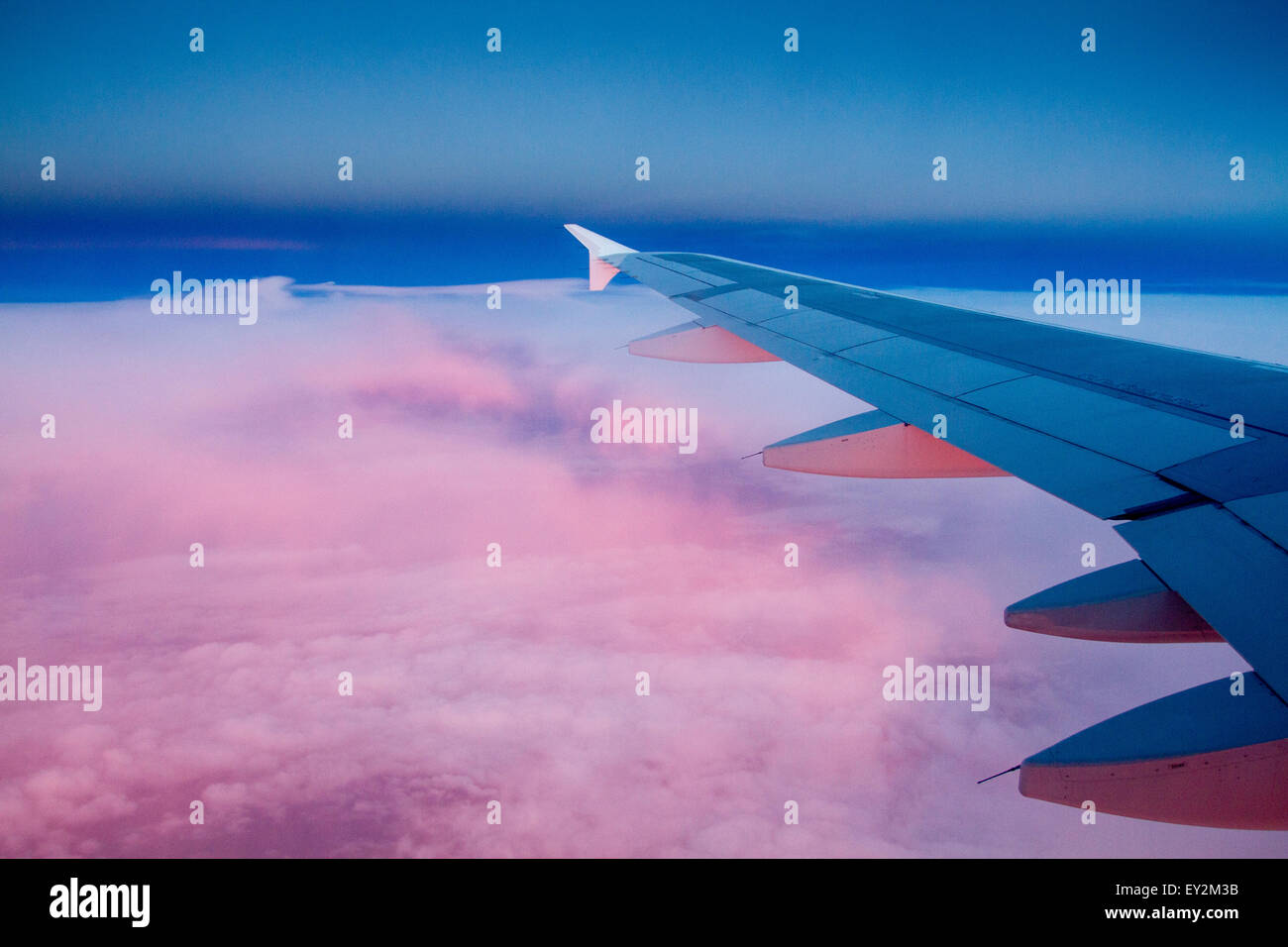 Airplane flying over pink clouds on the sunset Stock Photo - Alamy