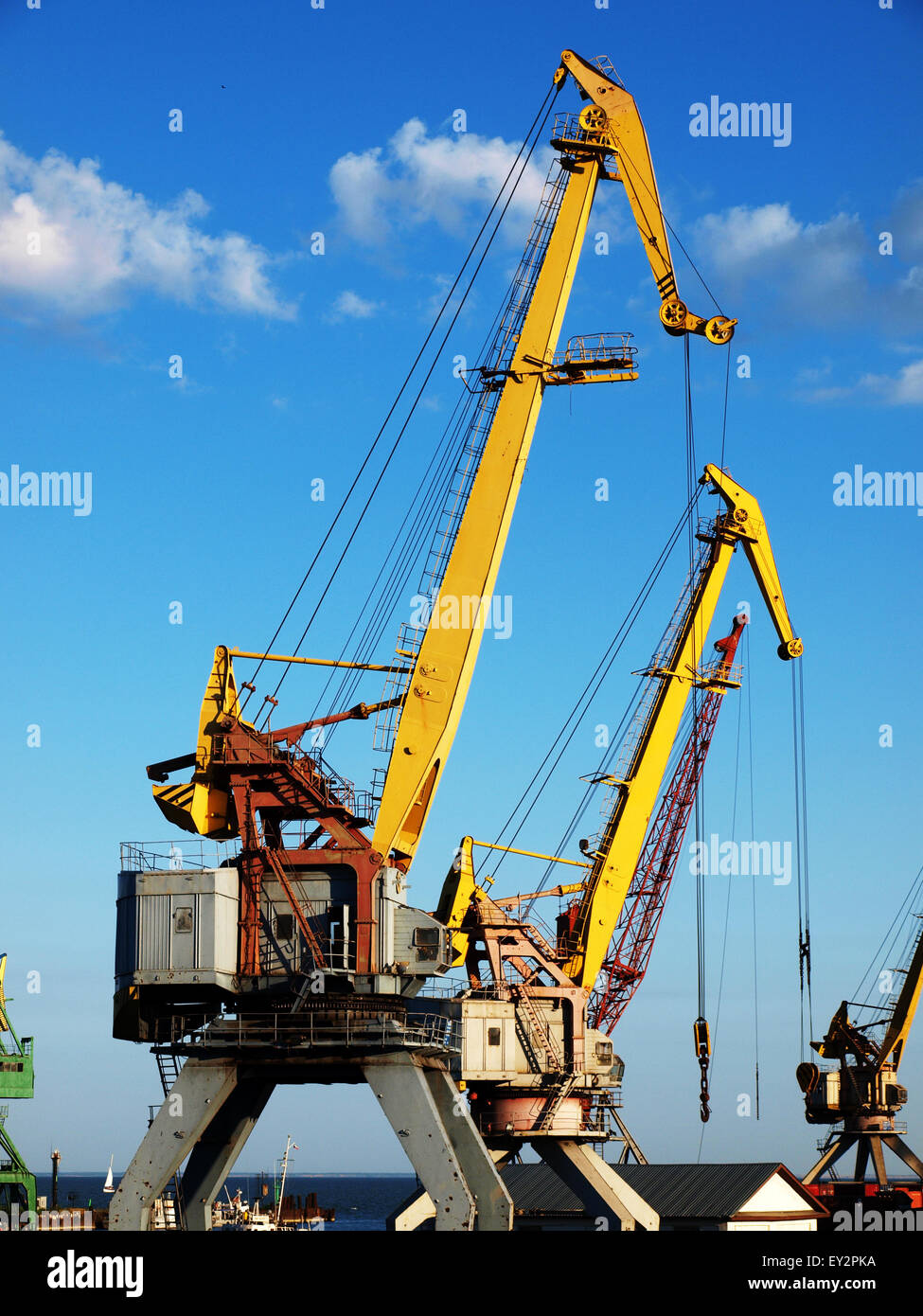 marine cranes in the cargo port closeup to the background of blue sky ...