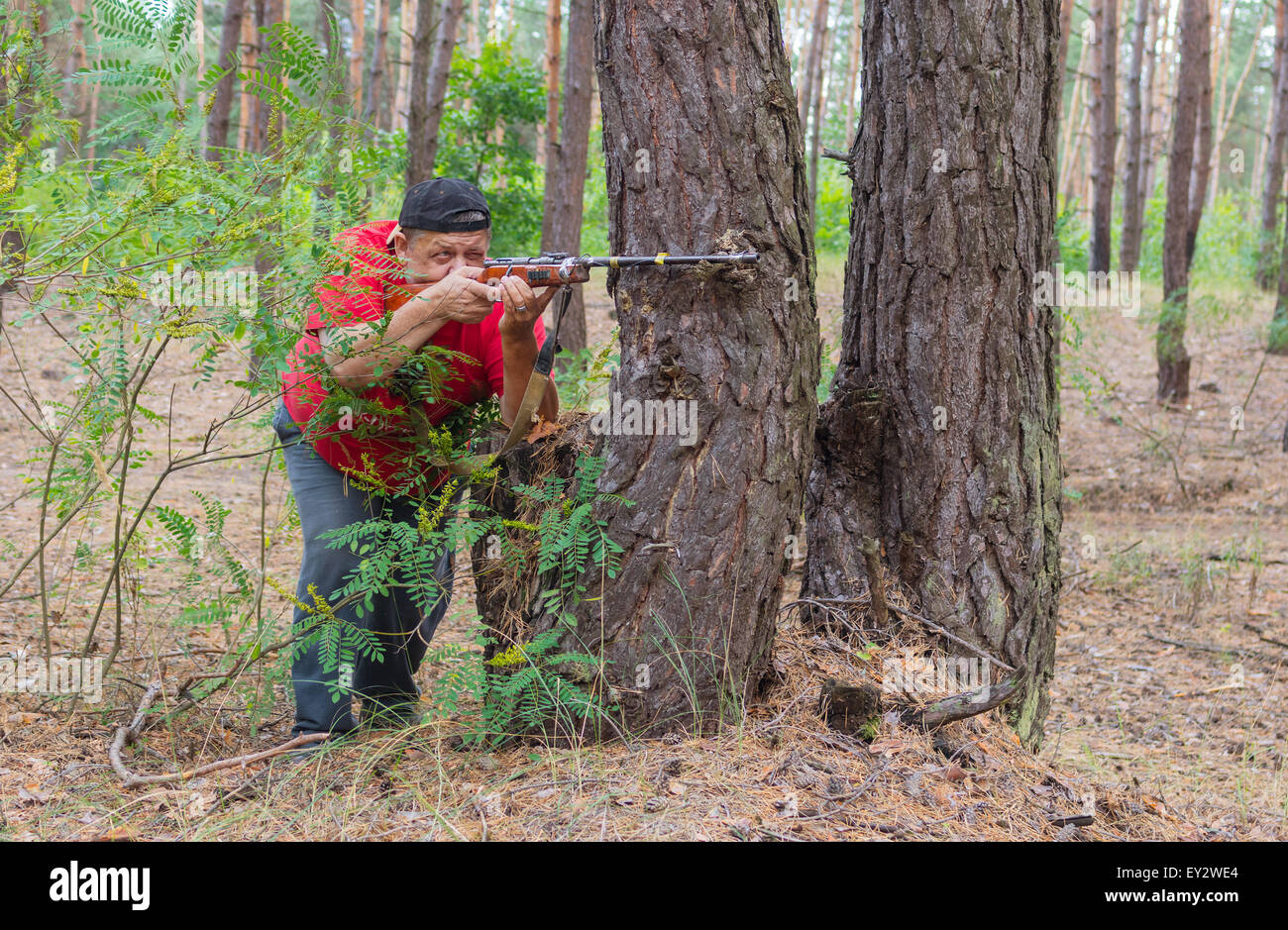 Old man shoots in forest Stock Photo - Alamy
