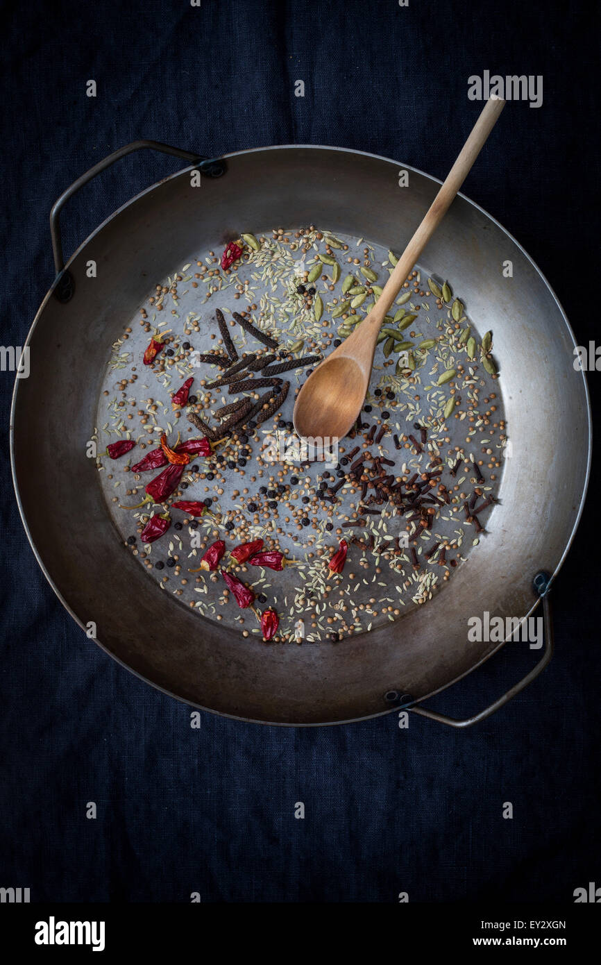 Whole spices prepared for roasting in a pan before dark background. Top ...