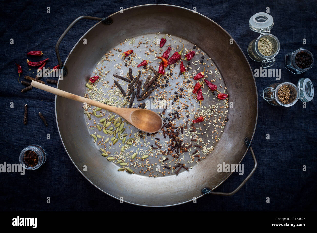 Whole spices prepared for roasting in a pan before dark background. Top ...