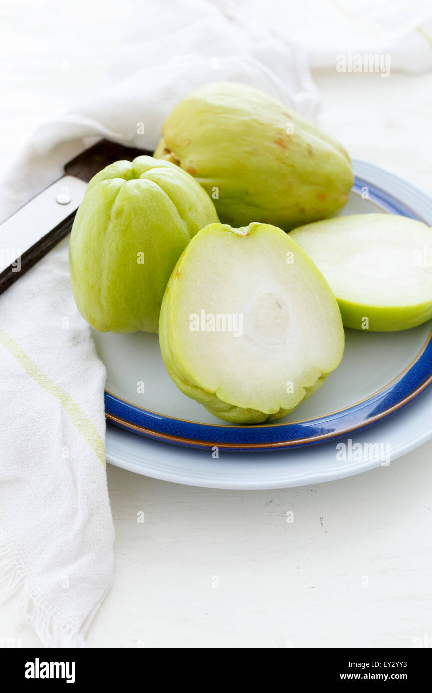 Chayotes on a plate, one of them sliced Stock Photo - Alamy