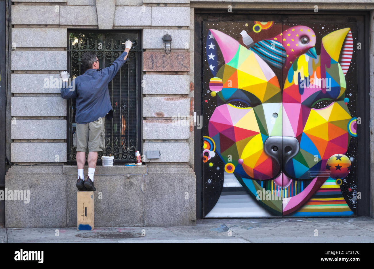 A man doing building maintenance, treating metal for rust, on a Soho ...