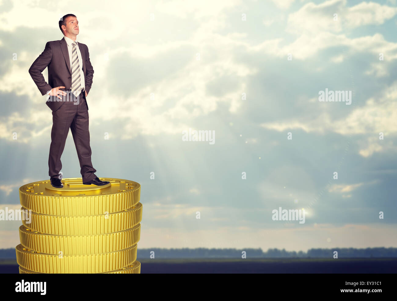 Businessman standing on coins stack Stock Photo - Alamy