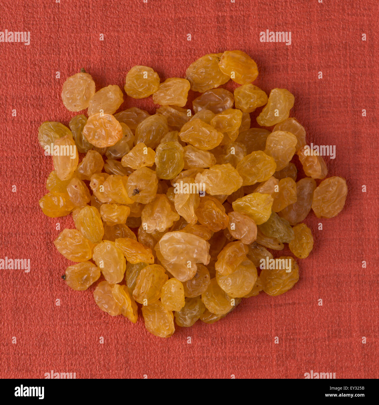 Top view of circle of golden raisins against red vinyl background Stock ...