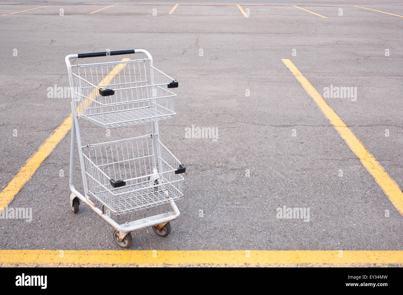 Empty shopping cart in empty parking lot Stock Photo - Alamy
