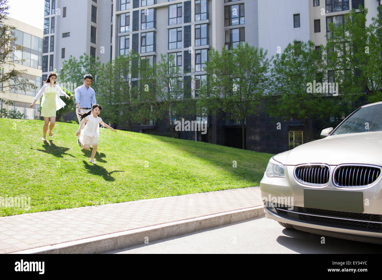Happy young family chasing outdoors Stock Photo - Alamy