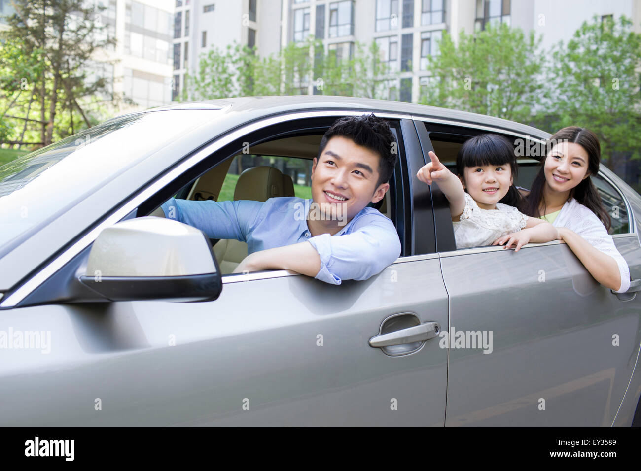 Happy young family in a car Stock Photo - Alamy