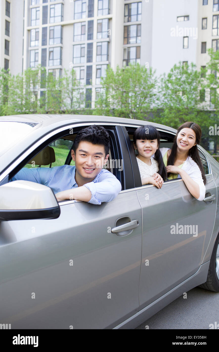 Happy young family in a car Stock Photo - Alamy