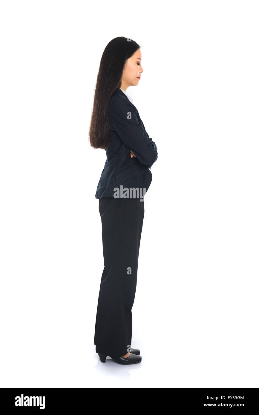 Side view of Asian business woman thinking, full length portrait ...
