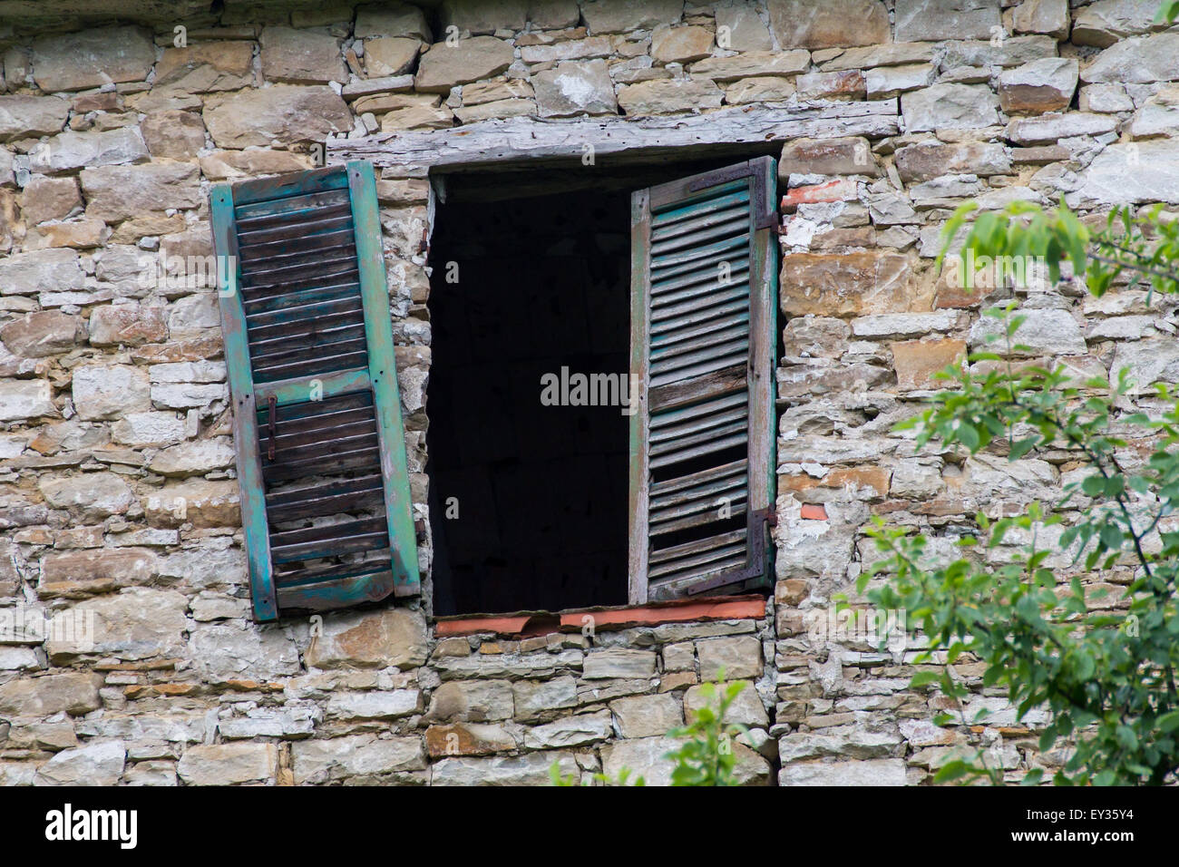 Broken window with green wooden shutter and without glasses in a stone ... Broken window with green wooden shutter and without glasses in a stone ...