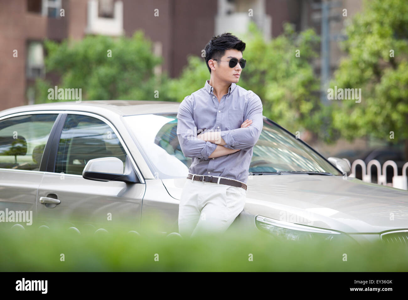 Young man leaning against his car Stock Photo - Alamy