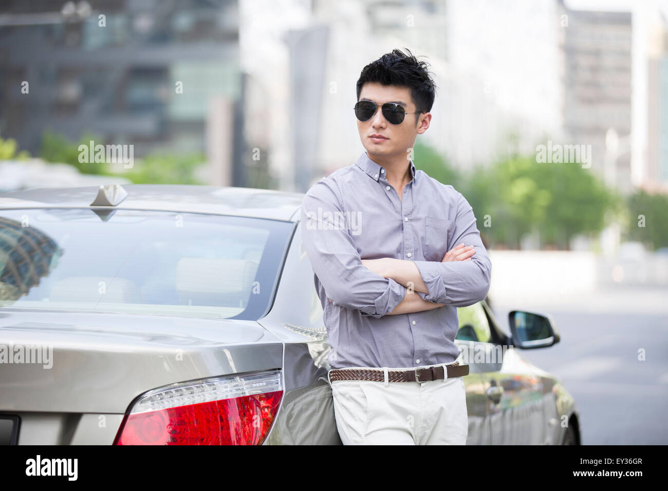 Young man leaning against his car Stock Photo - Alamy