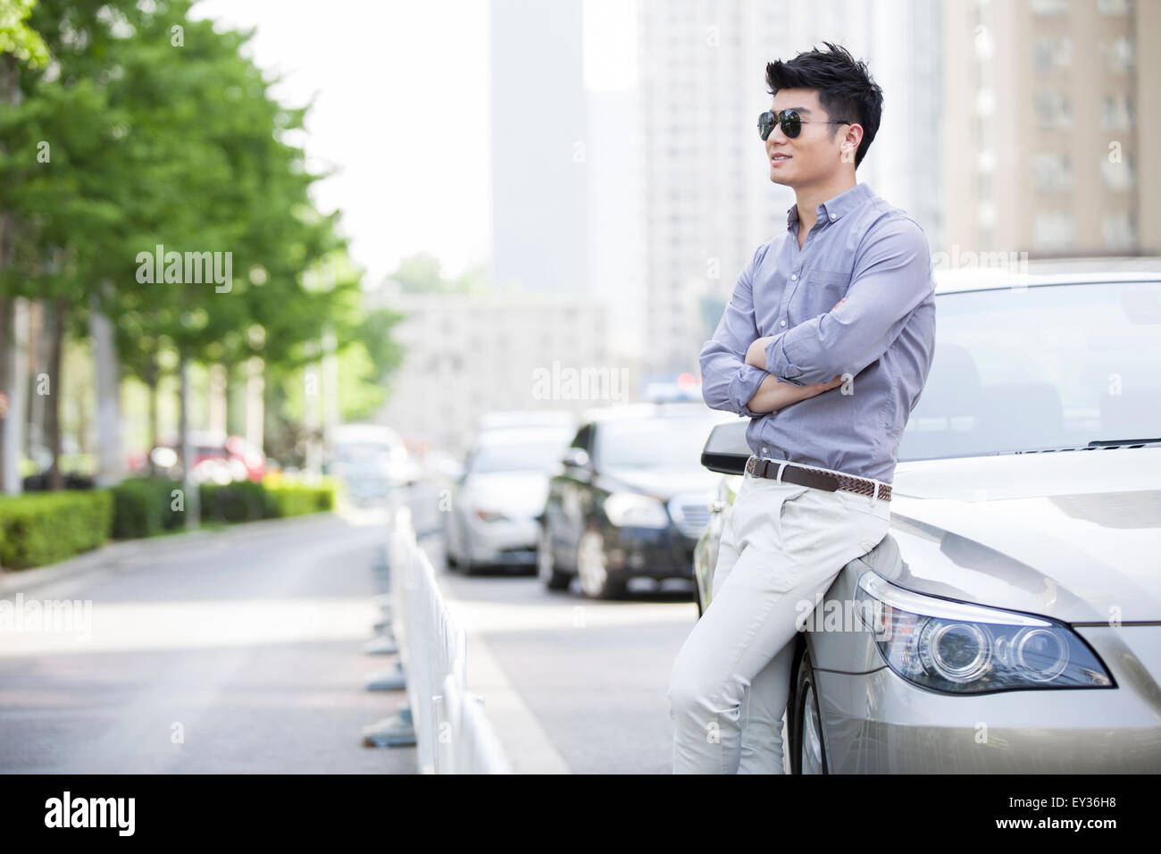 Young man leaning against his car Stock Photo - Alamy