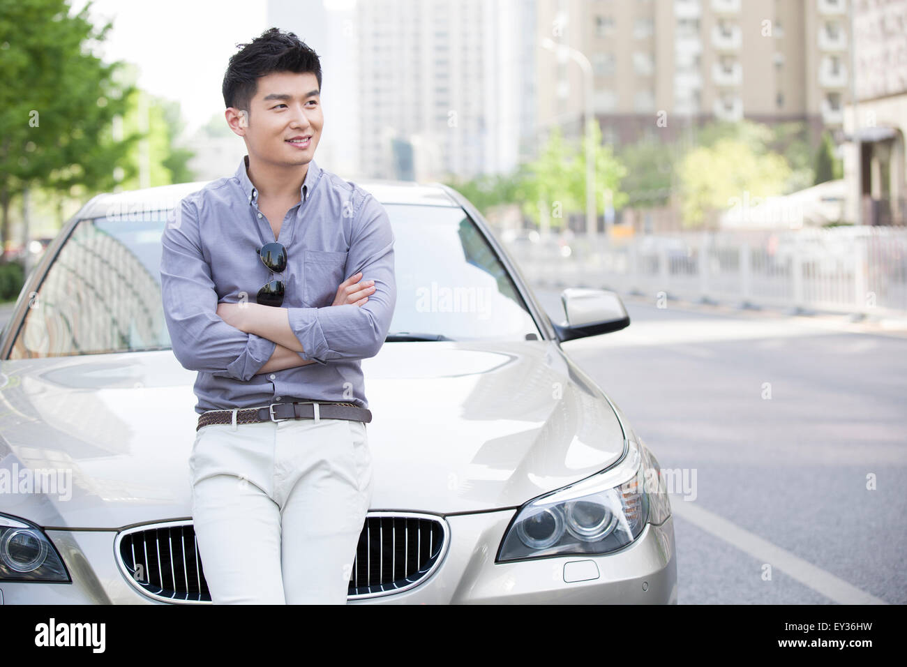 Young man leaning against his car Stock Photo - Alamy