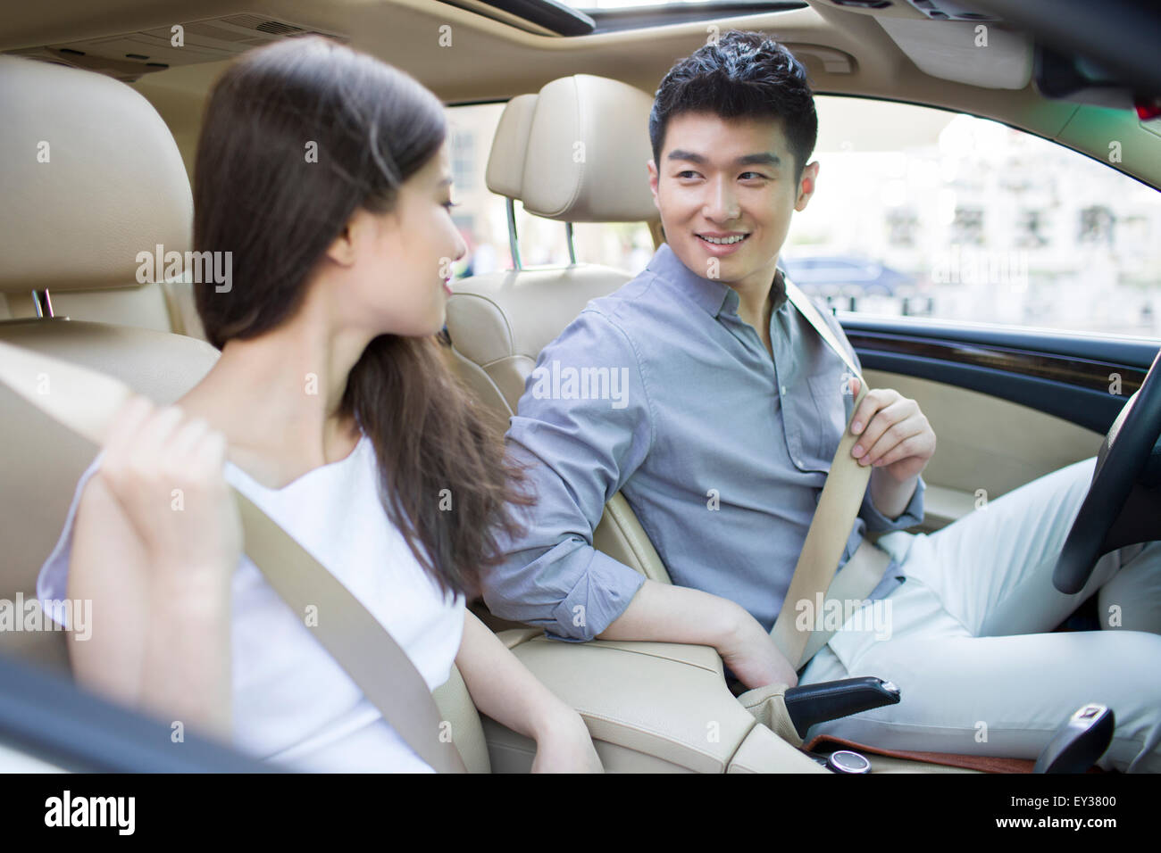 Happy young couple in a car Stock Photo - Alamy