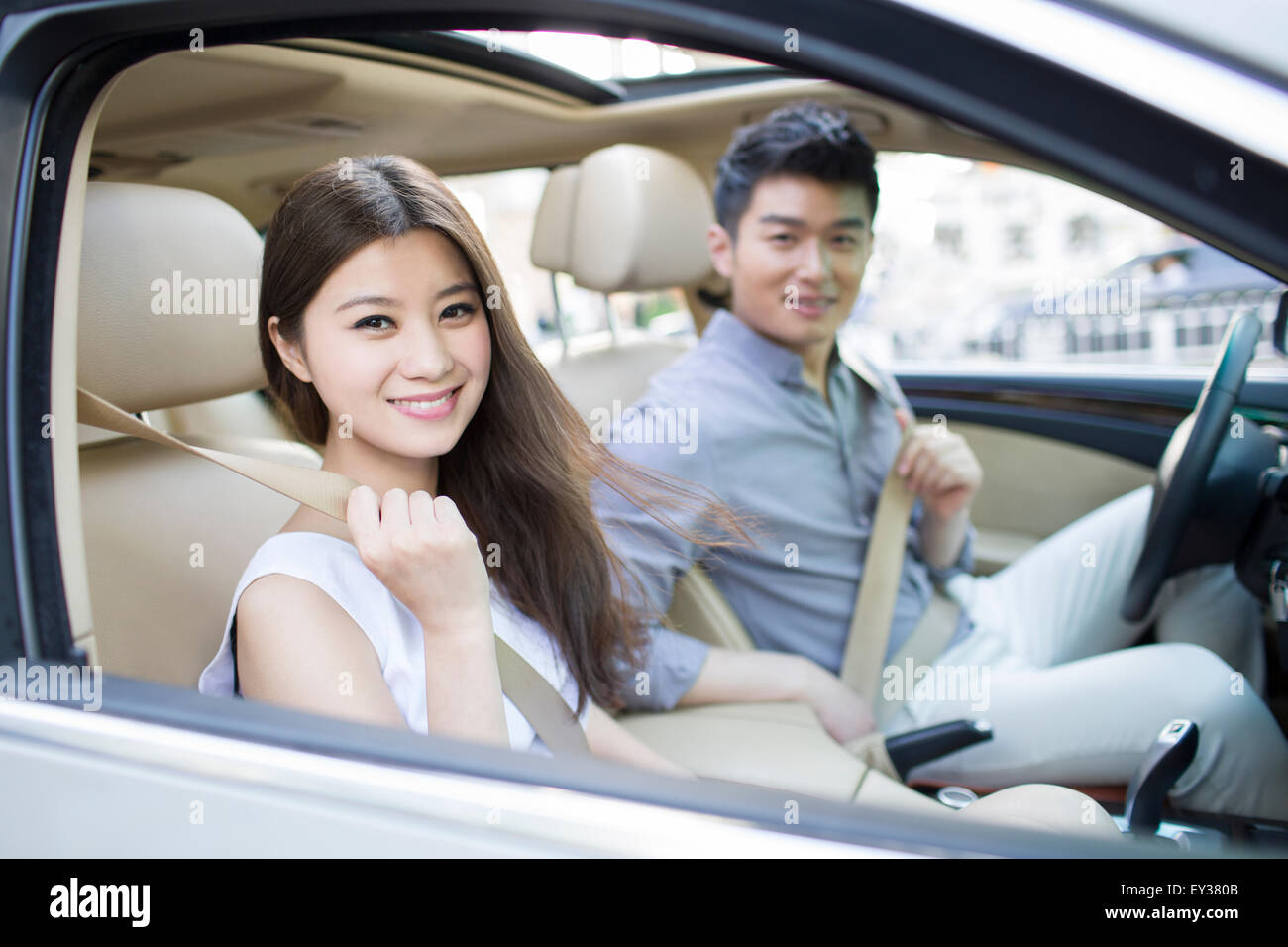 Happy young couple in a car Stock Photo - Alamy