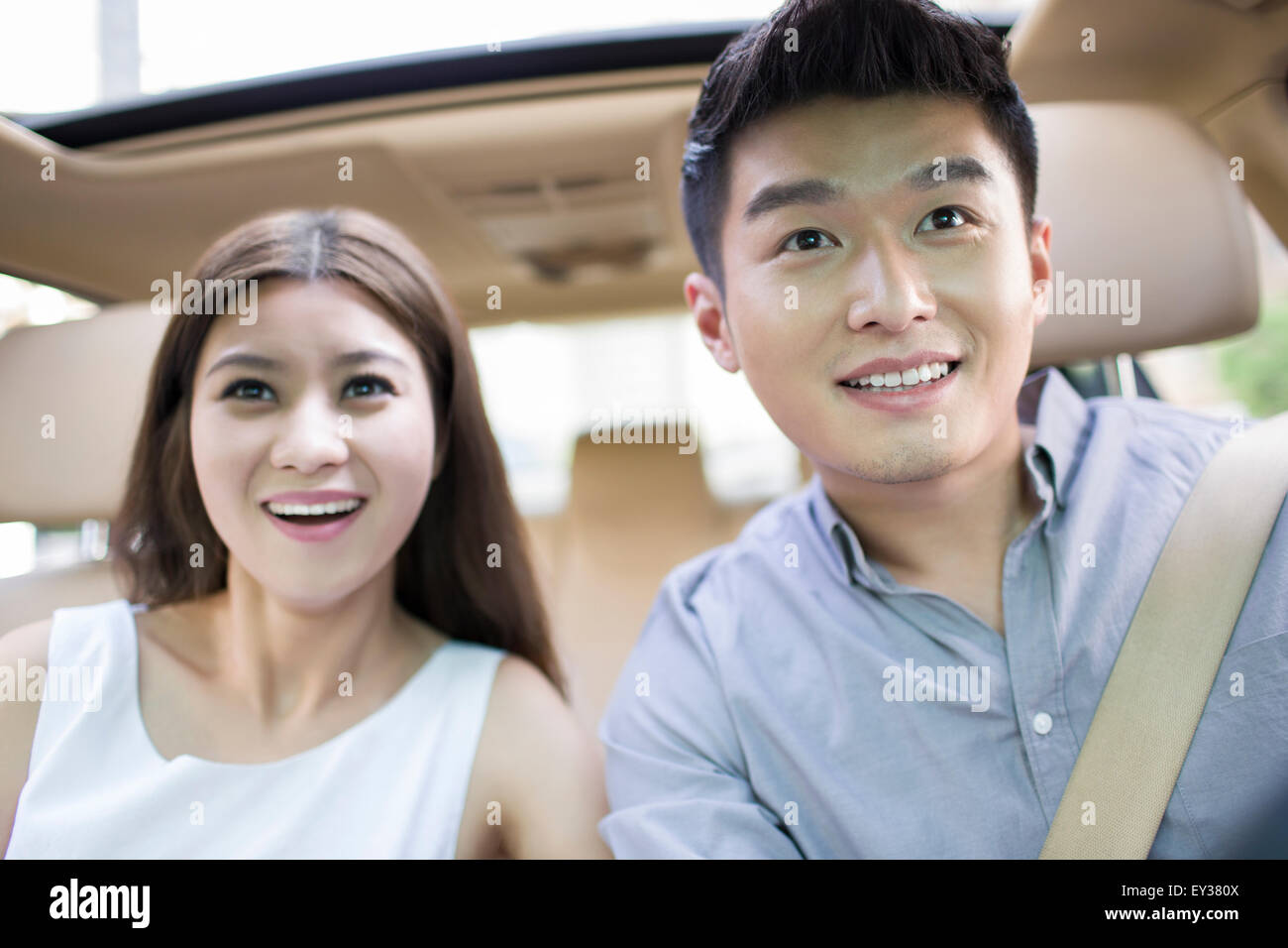 Happy young couple in a car Stock Photo - Alamy