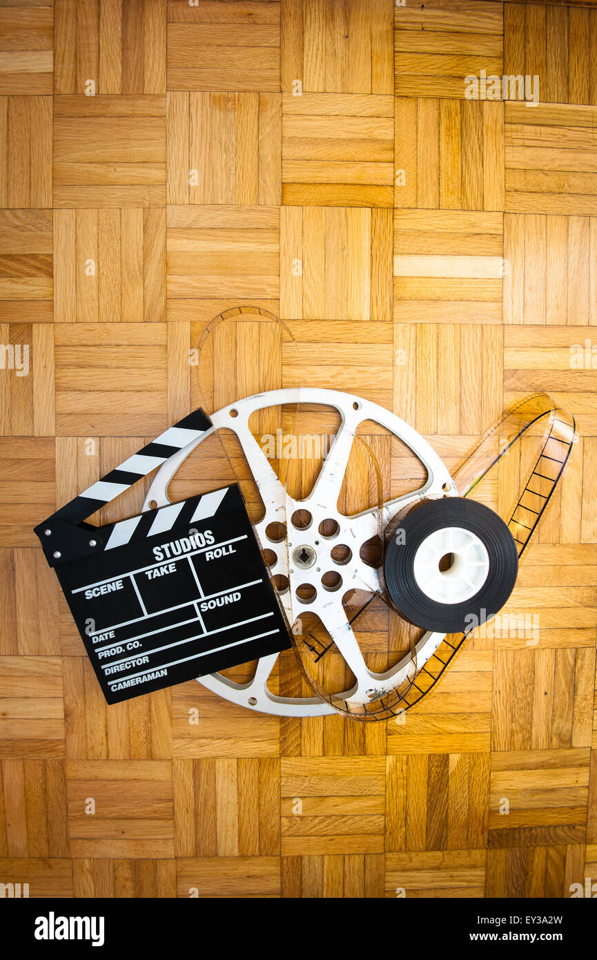Cinema movie clapper board with 35 mm filmstrip and reel on wooden ...