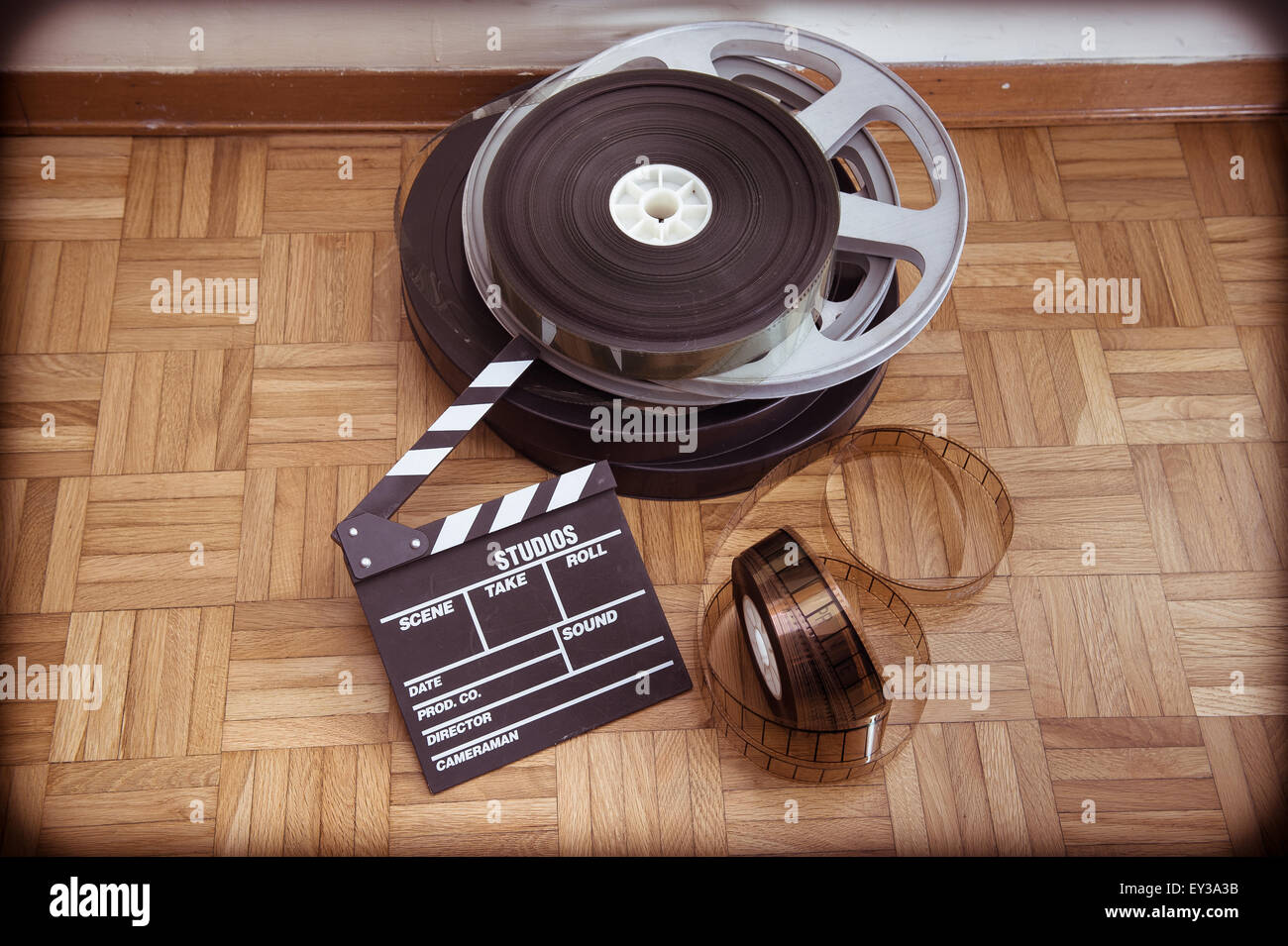 Cinema movie clapper board and 35 mm film reel on wooden floor vintage ...