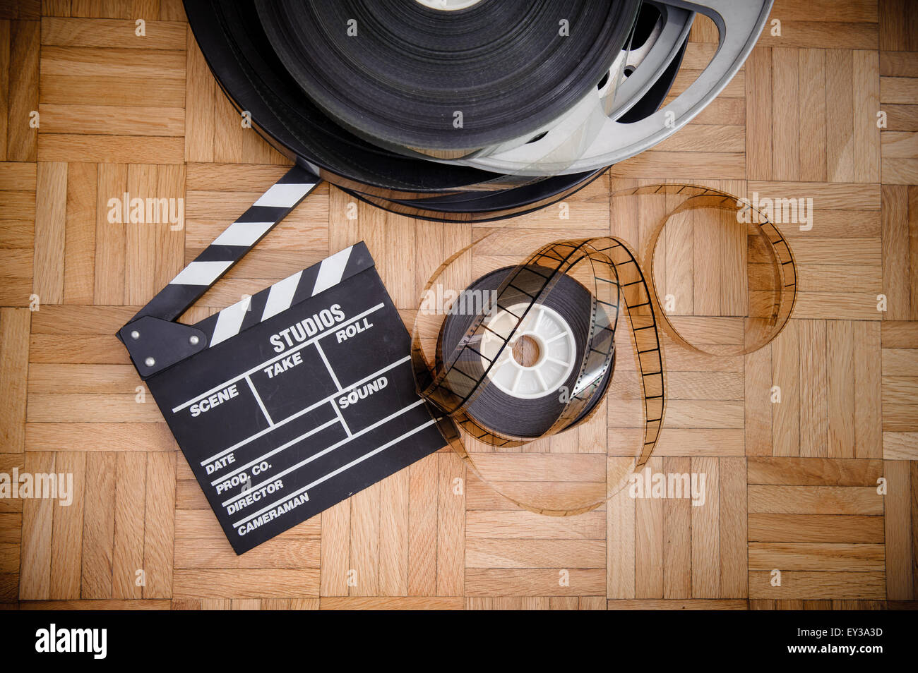 Cinema movie clapper board and 35 mm film reel on wooden floor vintage ...