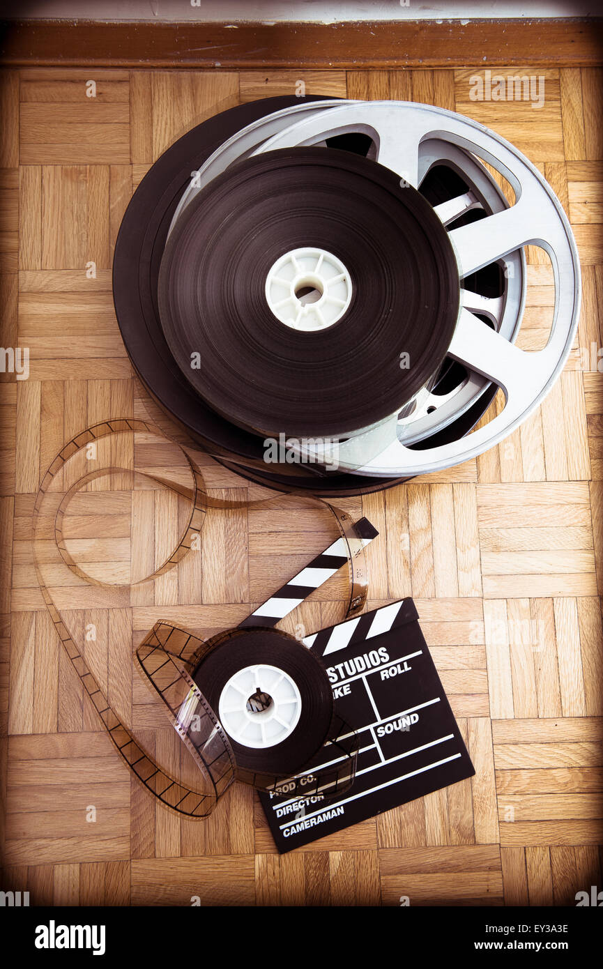 Cinema movie clapper board and 35 mm film reel on wooden floor vintage ...
