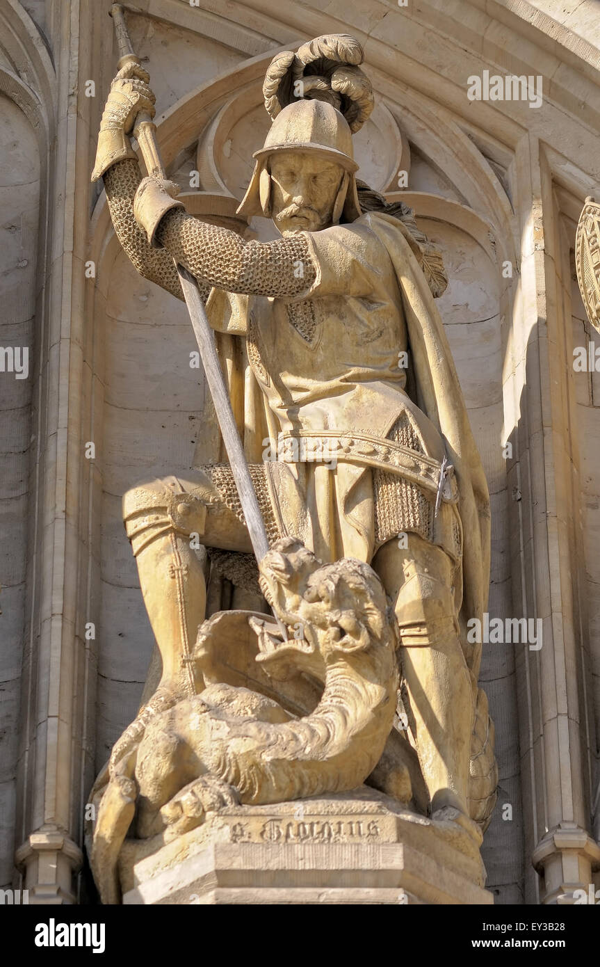 Medieval statue of Archangel Michael killing a devil on entry arch to ...
