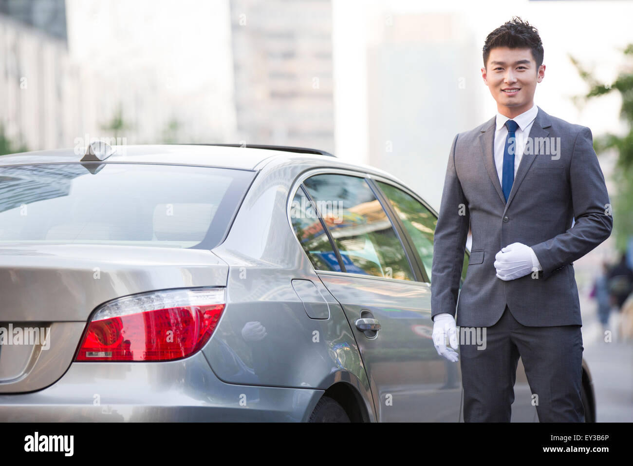 Portrait of chauffeur standing next to the car Stock Photo - Alamy